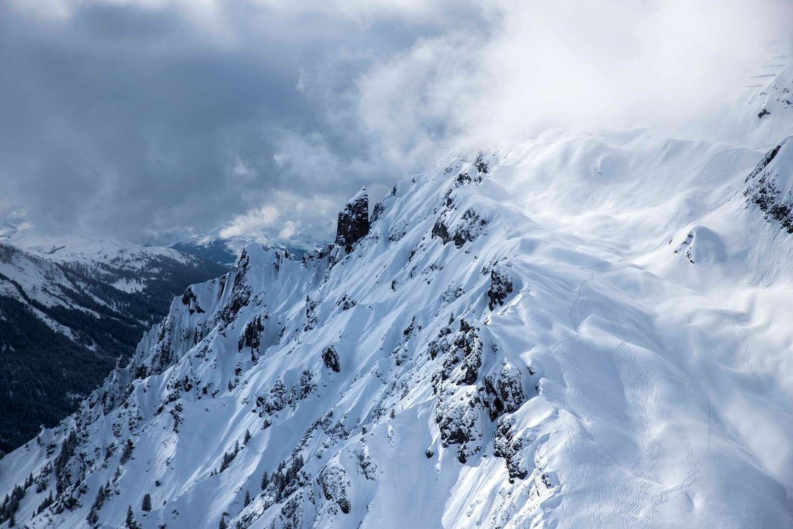 Fotobehang - Verse sporen in stille sneeuwhelling - Fotobehang